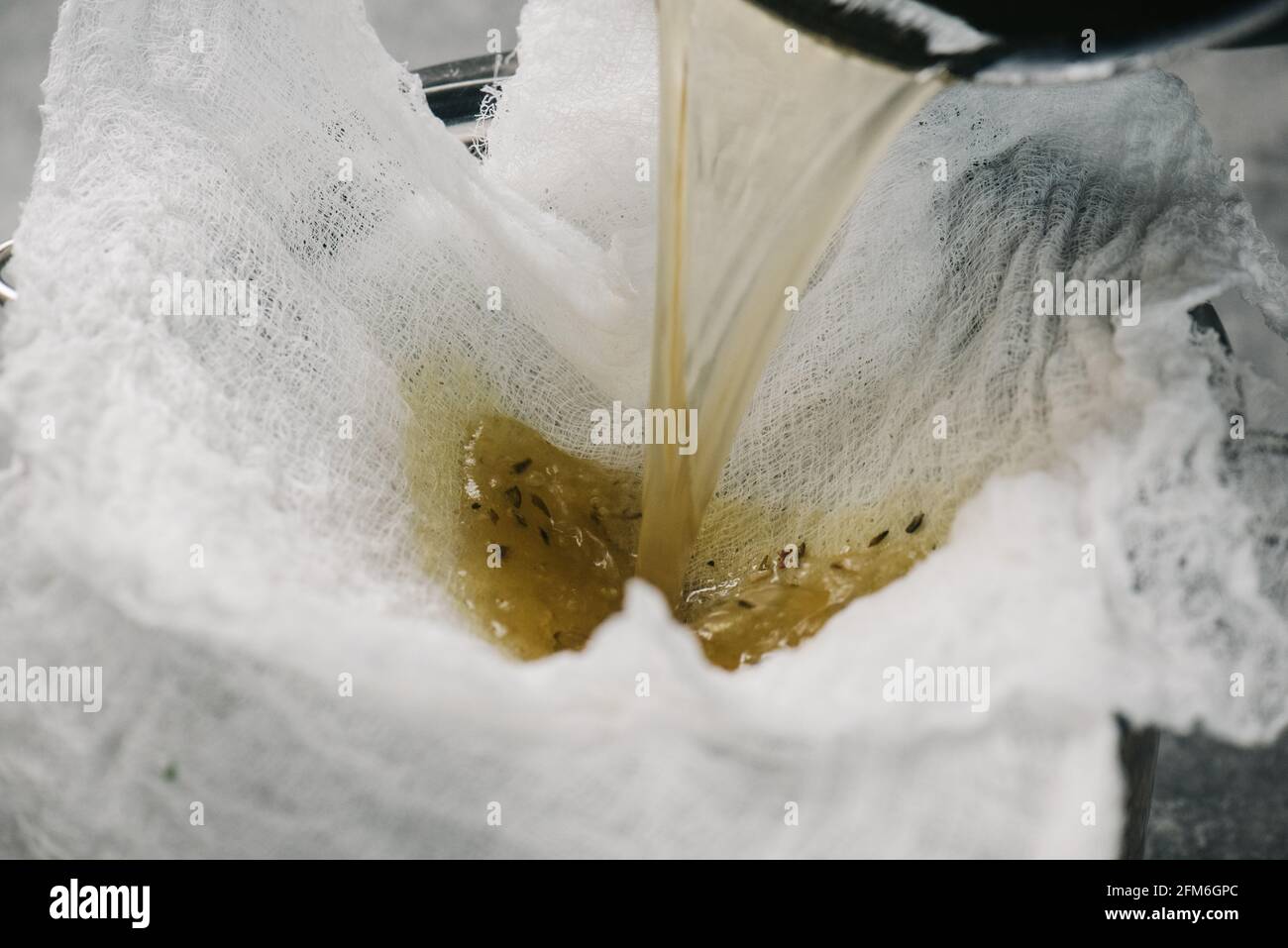 Bone broth being strained through cheese cloth Stock Photo - Alamy