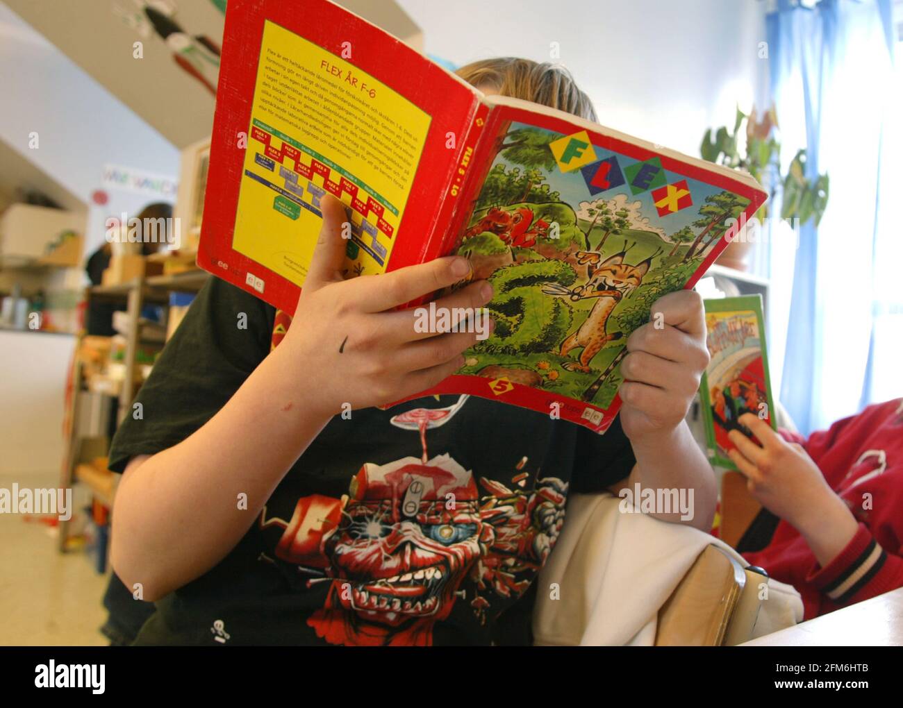 Pupil reading a book during a lesson at a low school middle school ...
