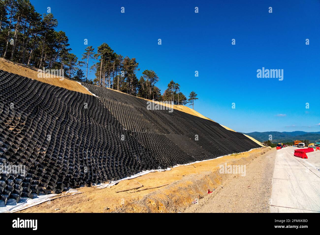 Metal mesh to strengthen the slope of the road Stock Photo - Alamy