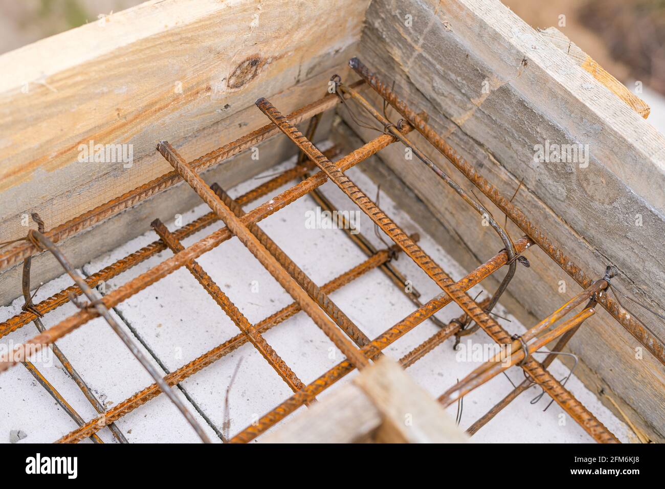 Reinforced belt in wooden formwork at a construction site close up ...