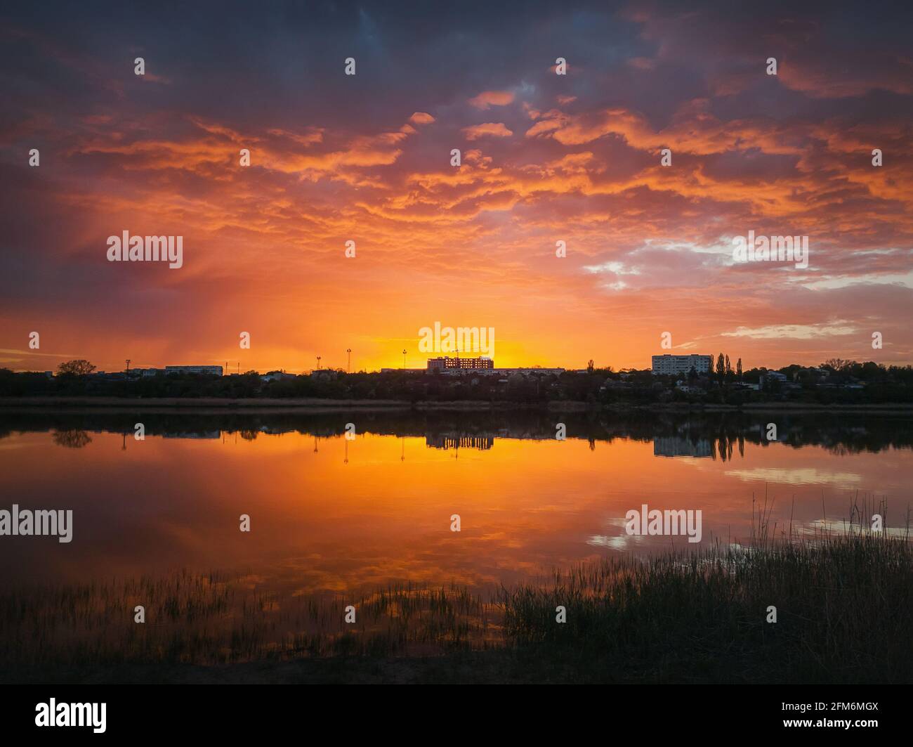 Colorful and dramatic sunset sky reflecting on pond water. Silent ...