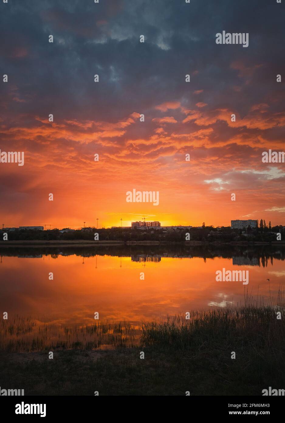Colorful and dramatic sunset sky reflecting on pond water. Silent ...