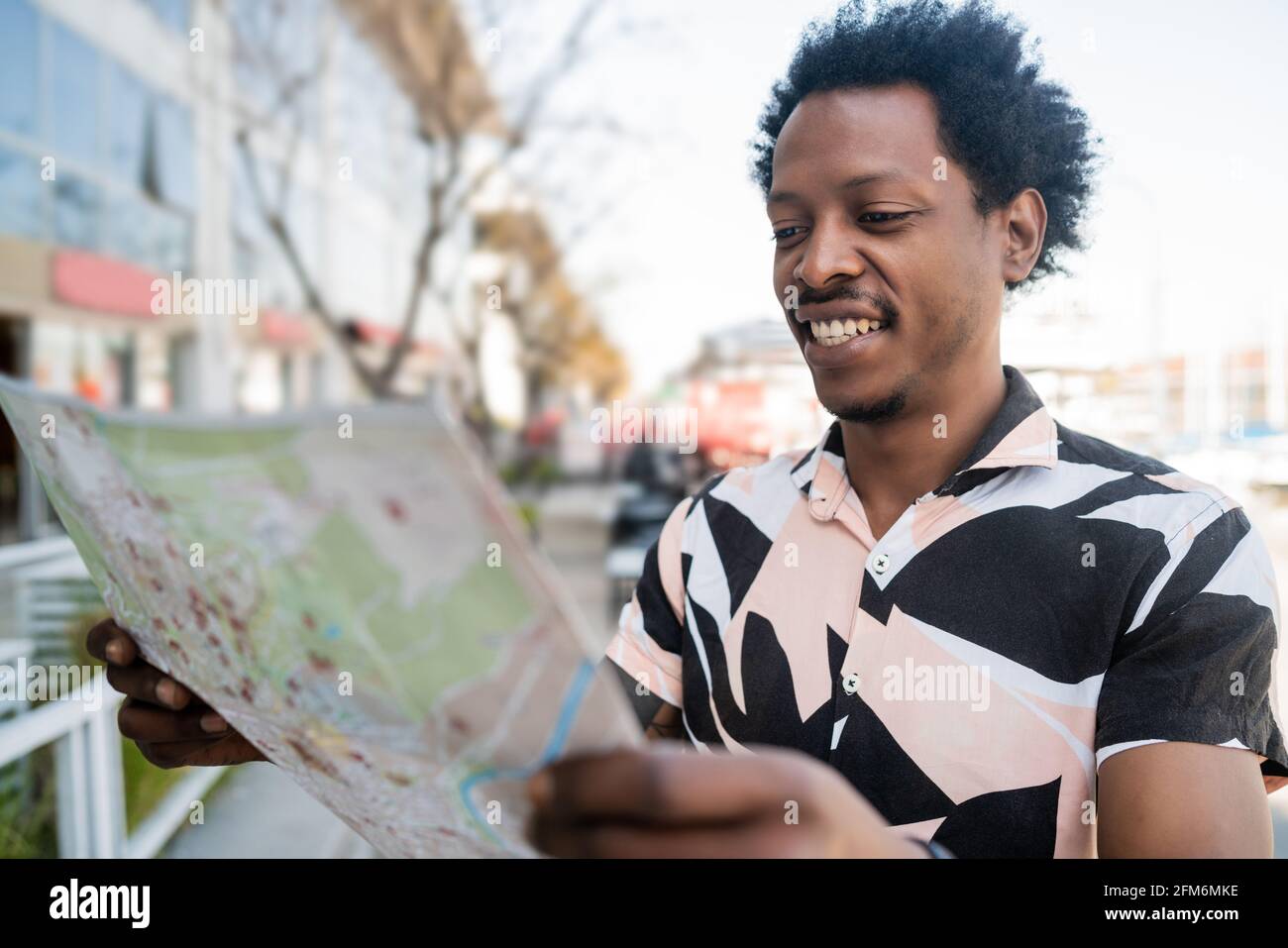 Tourist man looking for directions on map Stock Photo - Alamy