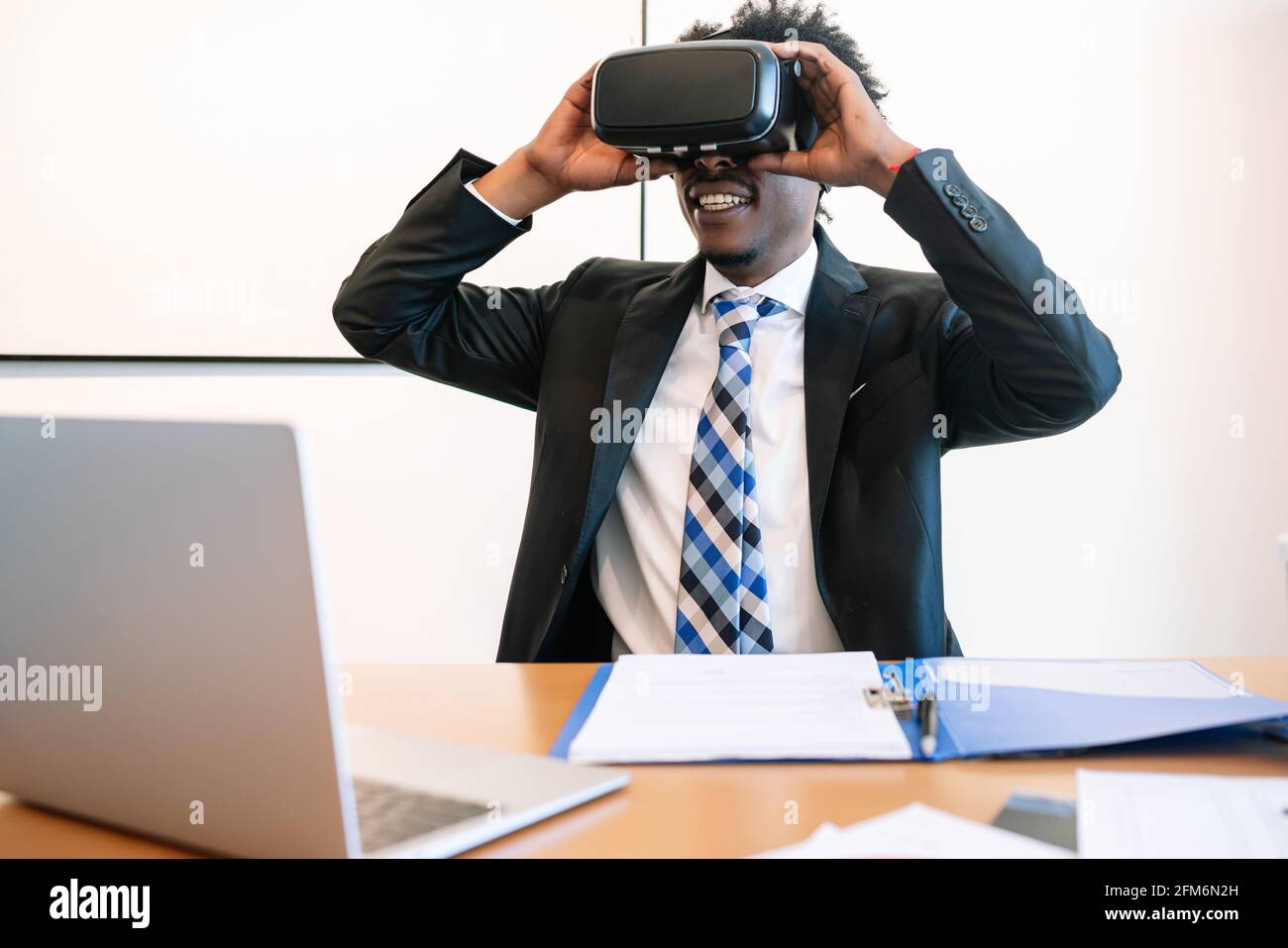 Businessman using virtual reality headset Stock Photo - Alamy