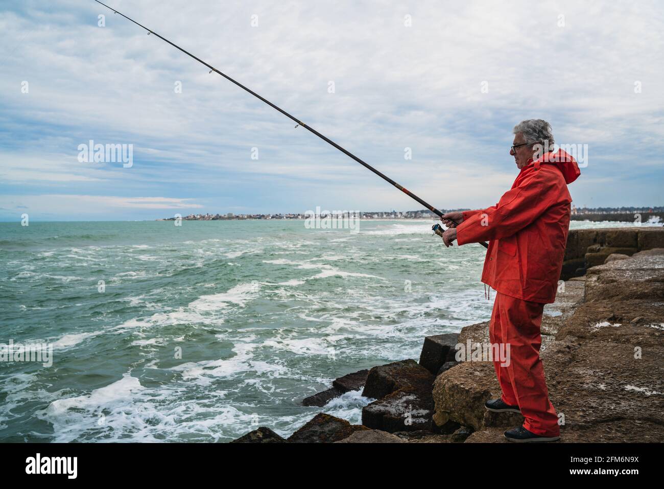 Old man fishing in the sea Stock Photo - Alamy