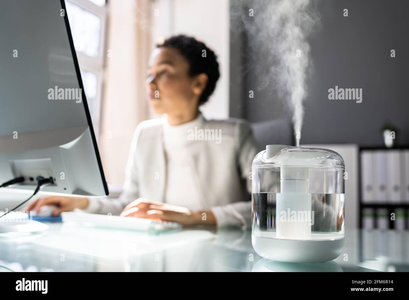 African American Woman In Office With Air Humidifier Stock Photo - Alamy