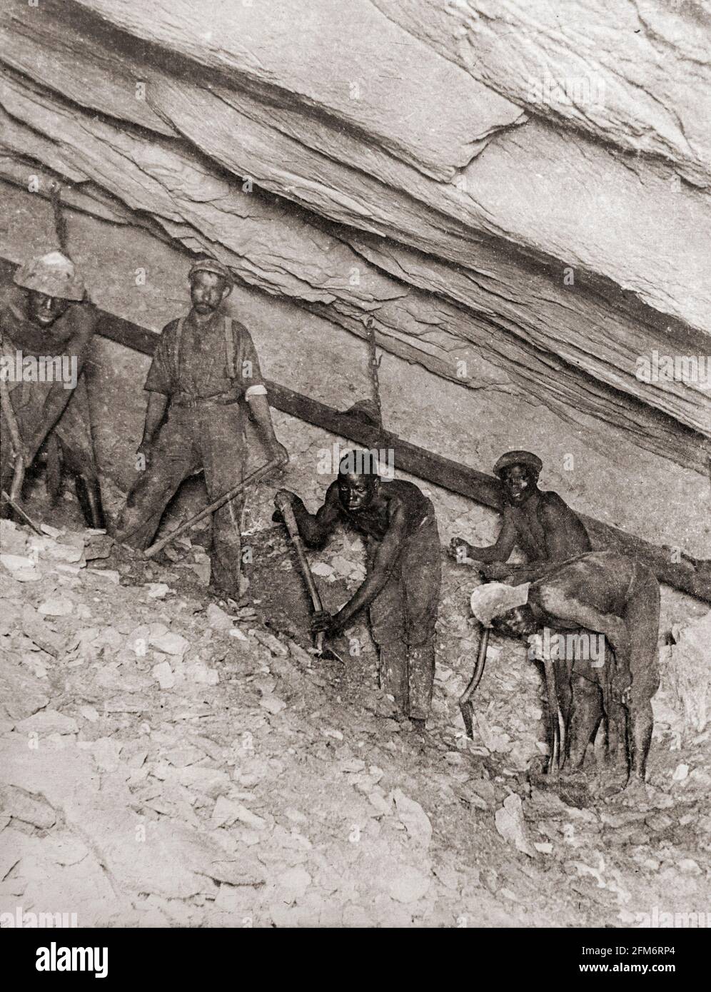 Curring a stope with black men with bare feet, gold mining, South ...