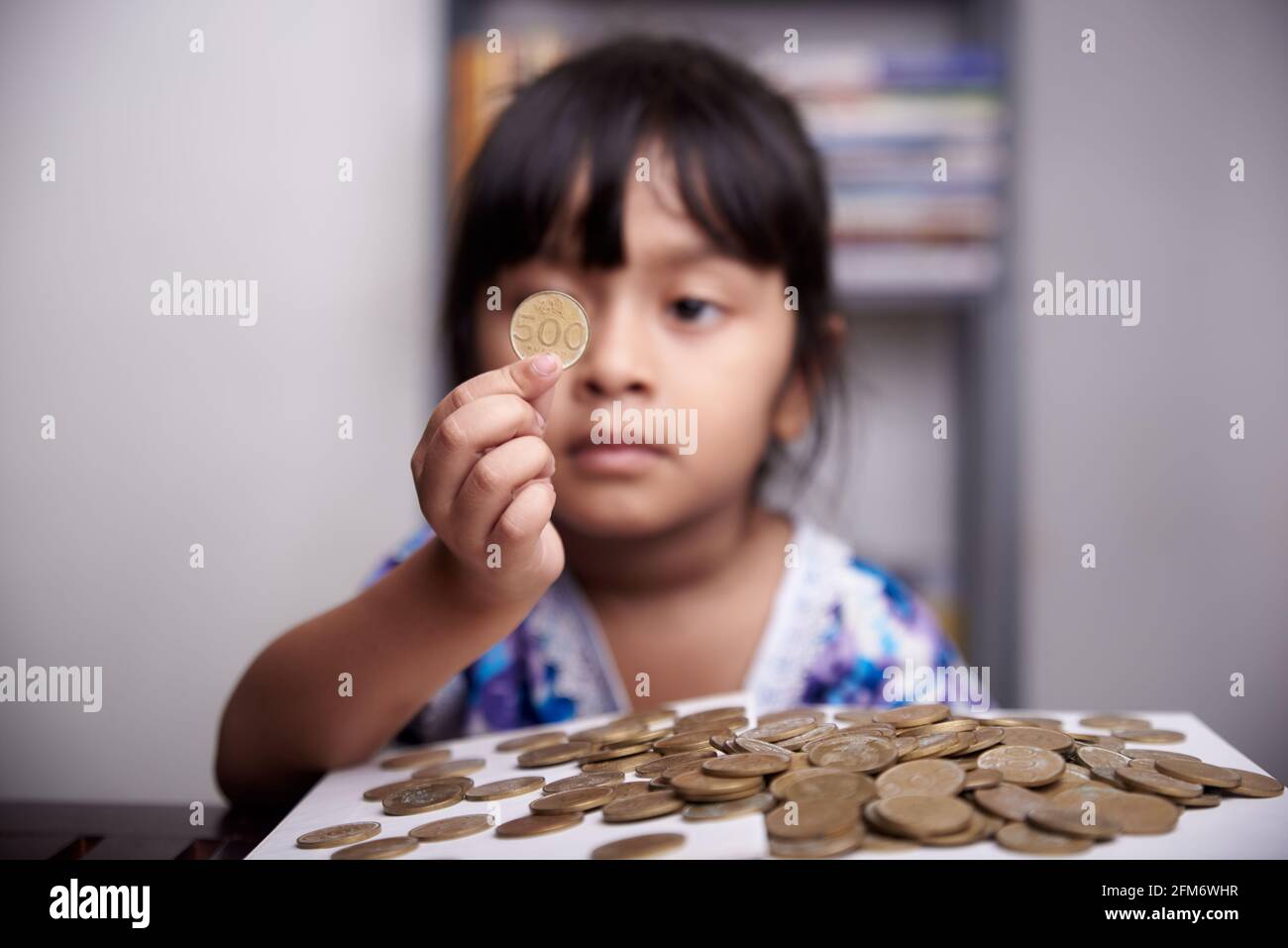 Little cute Girl is counting bunch of coins Stock Photo - Alamy