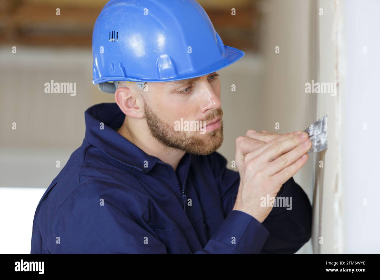worker filling a wall with putty Stock Photo - Alamy