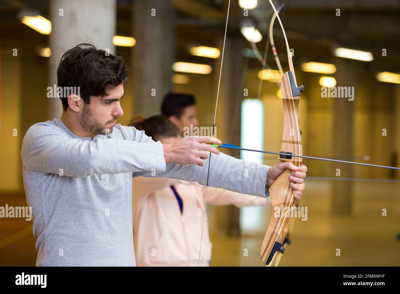 side view of young man practicing archery Stock Photo - Alamy