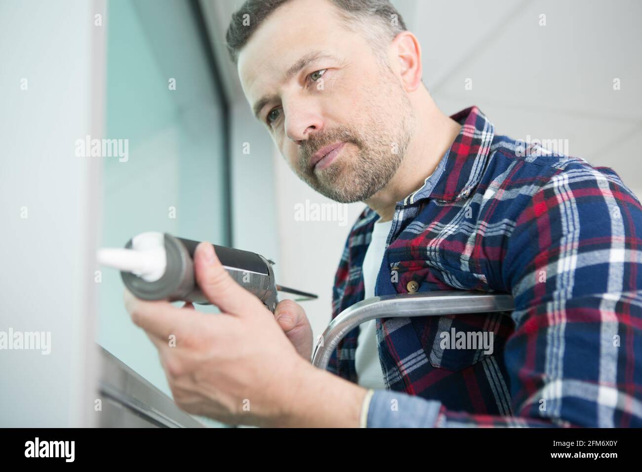 a man with silicone sealant Stock Photo - Alamy