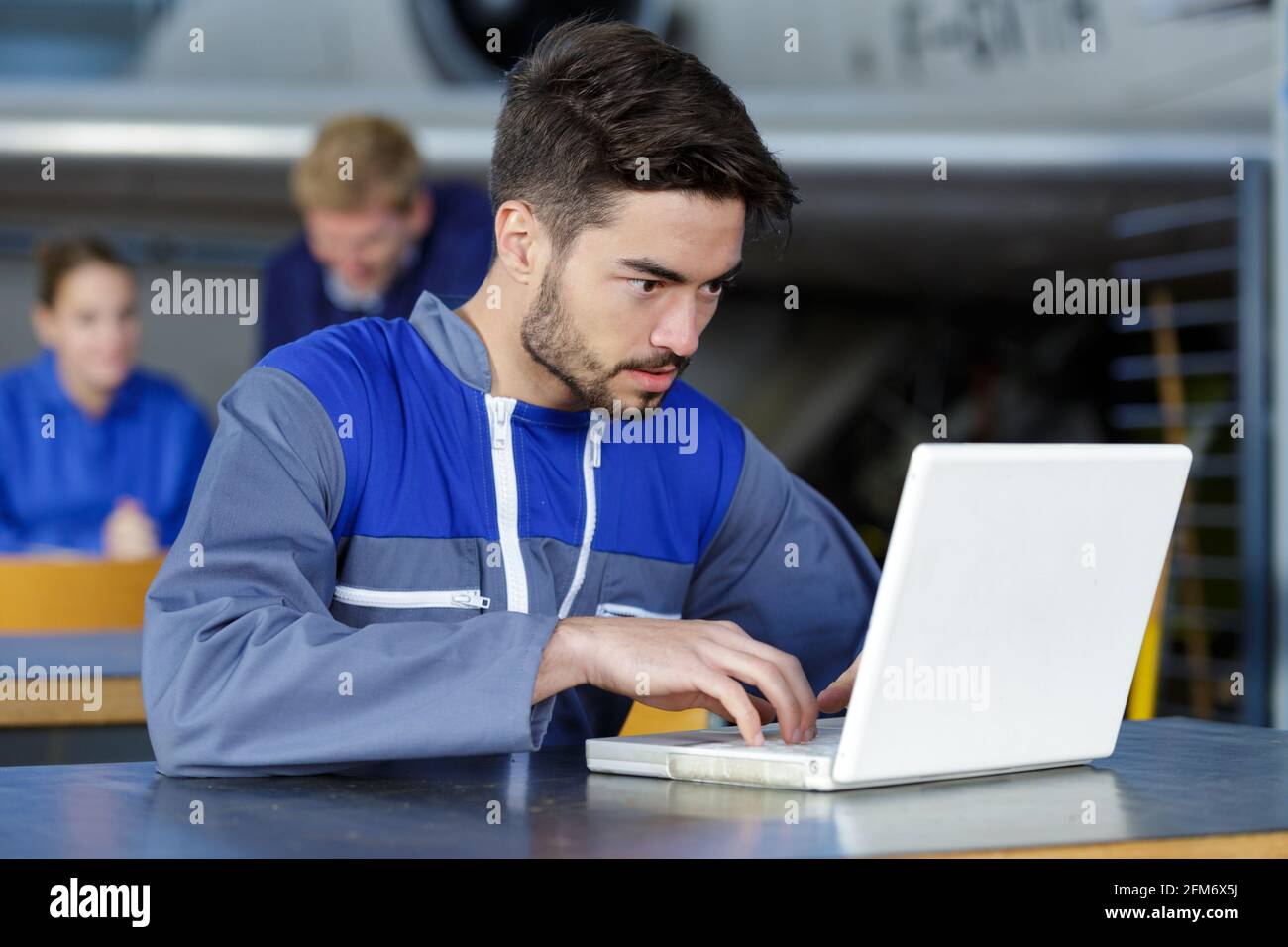 portrait of a male apprentice using laptop Stock Photo - Alamy