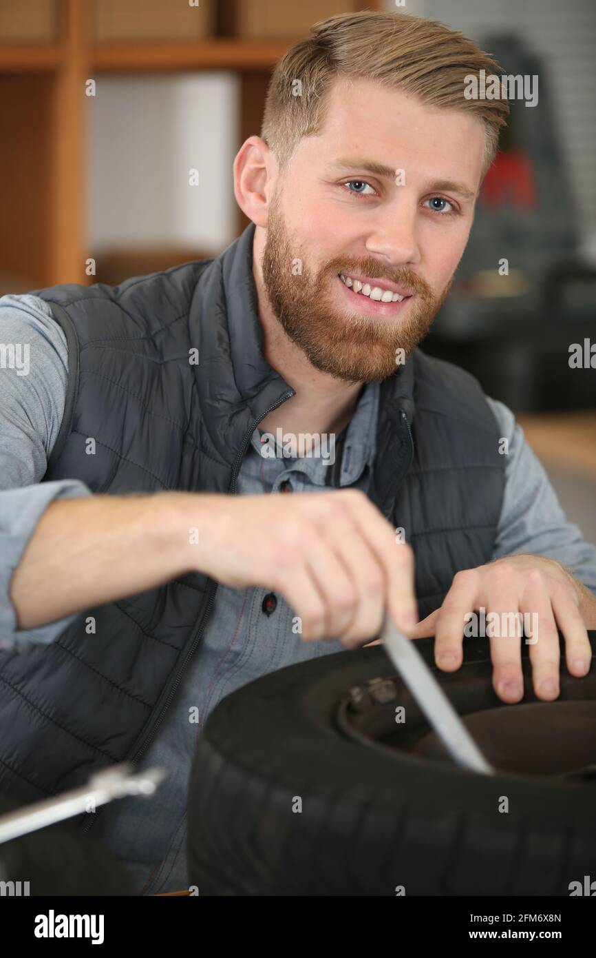 mechanic with car tyres in tyre store Stock Photo - Alamy
