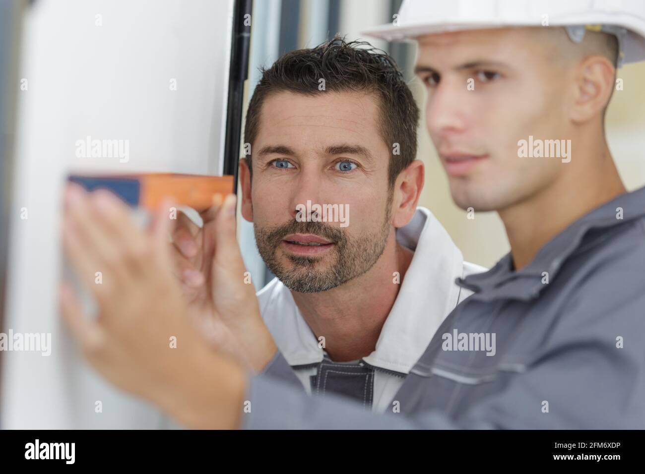 Men measure level hi-res stock photography and images - Alamy