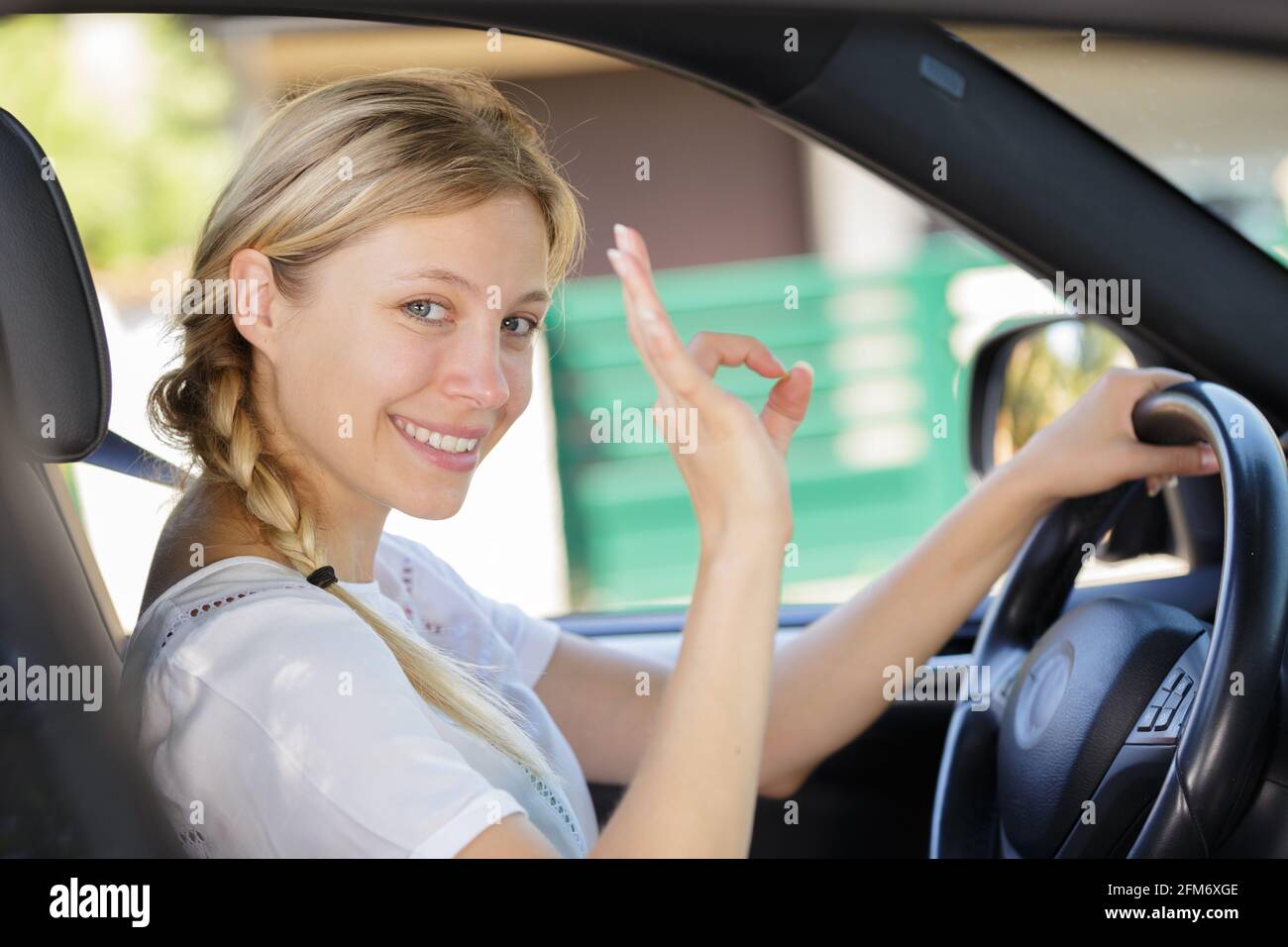 beautiful young woman is showing ok sign inside a car Stock Photo - Alamy