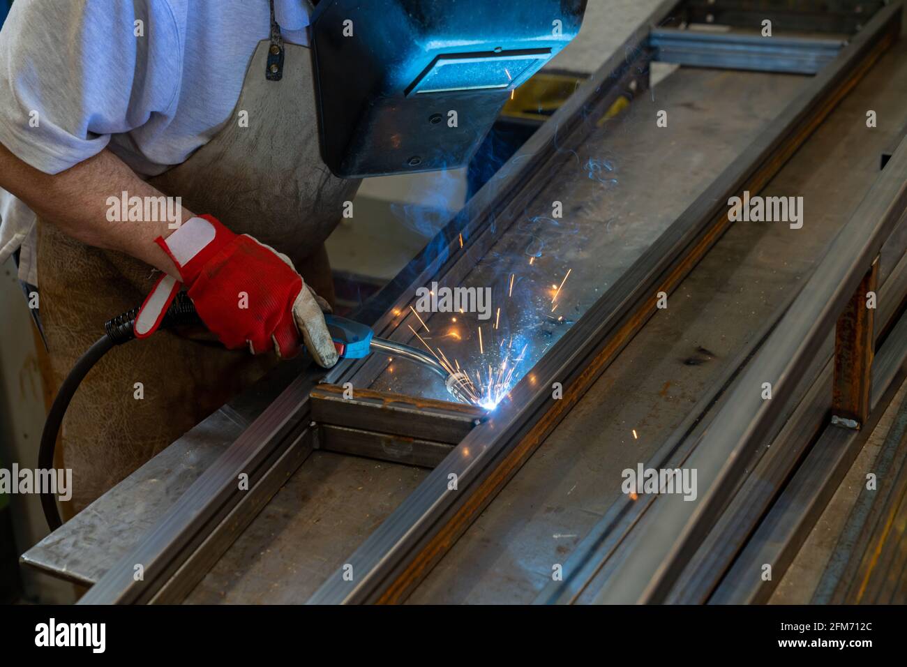 Man welding steel frames in a forgery and metal works workshop Stock ...