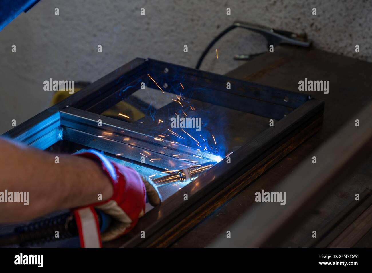 Man welding steel frames in a forgery and metal works workshop Stock ...