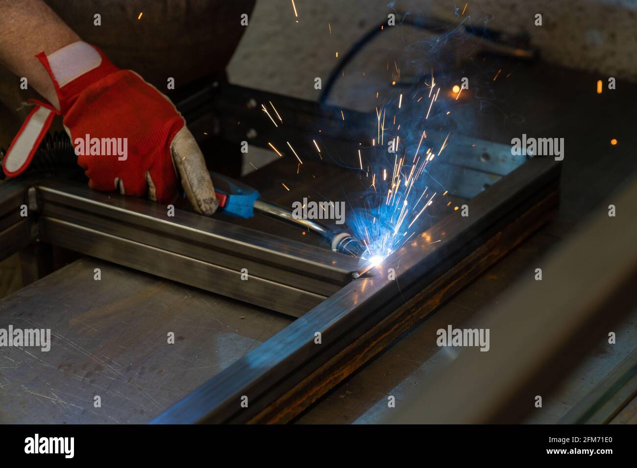 Man welding steel frames in a forgery and metal works workshop Stock ...