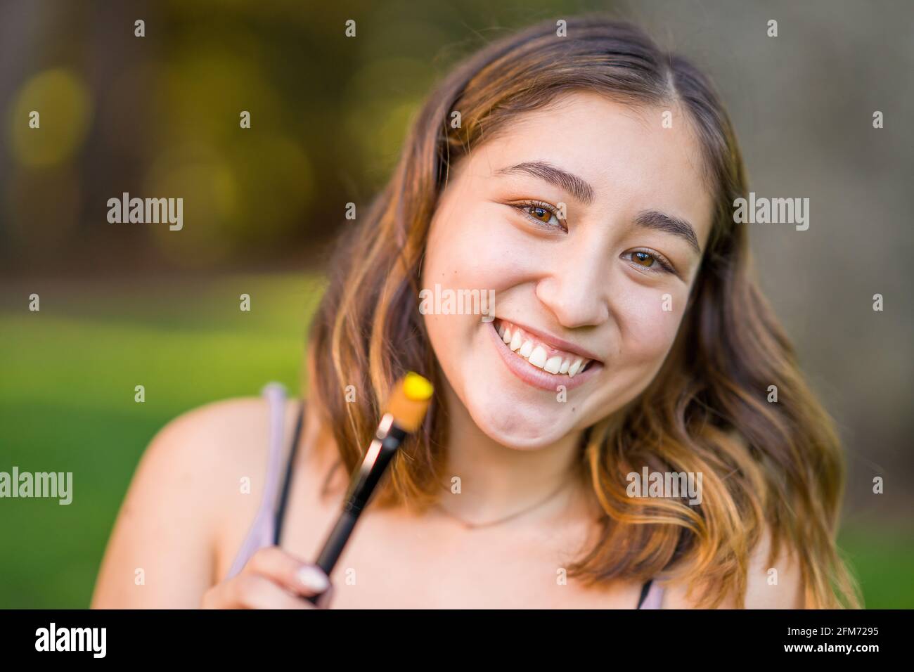 Petite Young Asian Woman Student Holding a Paint Brush with Yellow ...