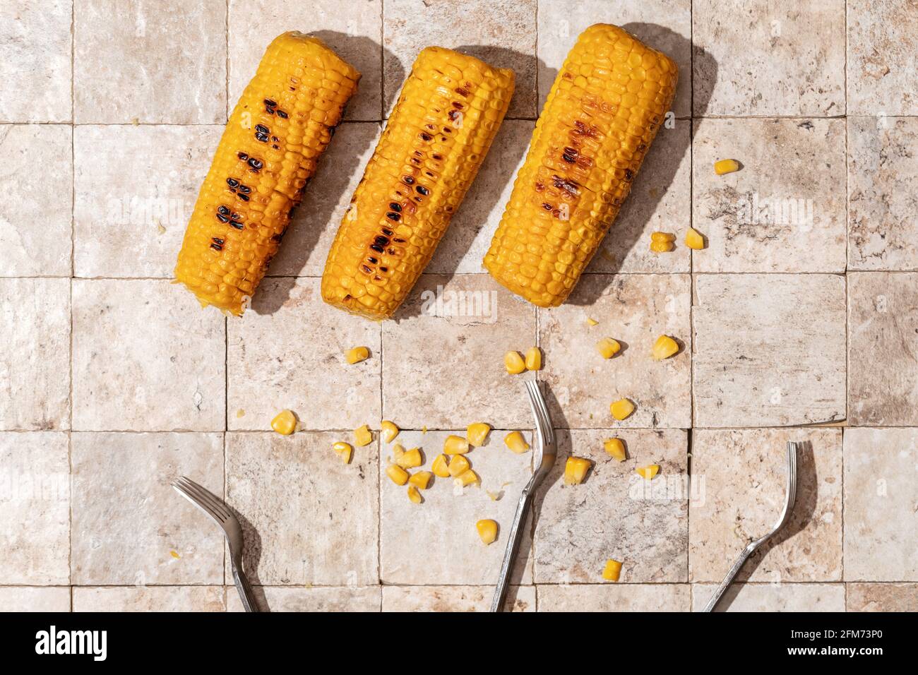 Delicious organic homemade hot grilled corn cobs with three forks on ...