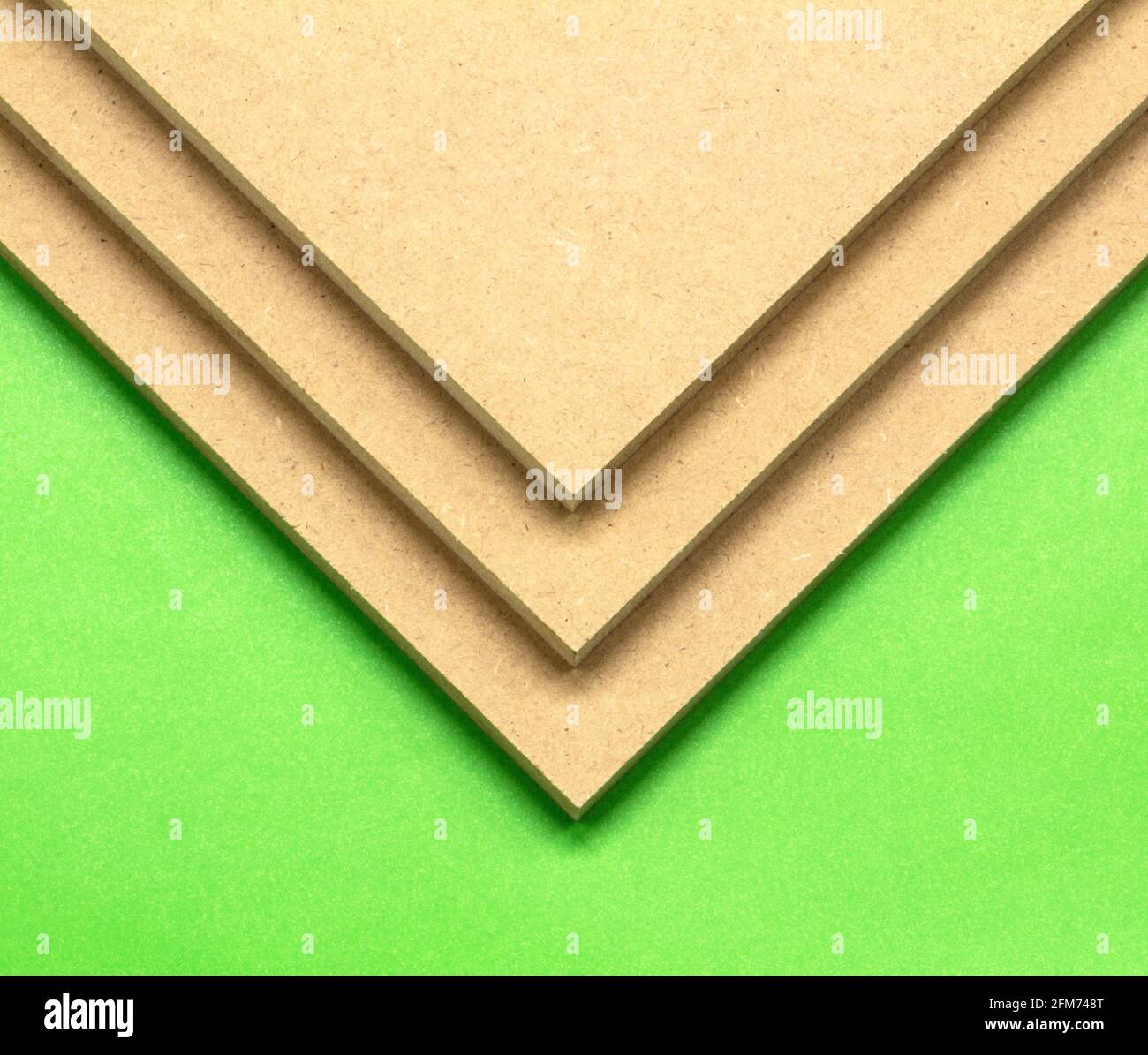 Three boards of raw MDF on a green background. They can be used in the ...