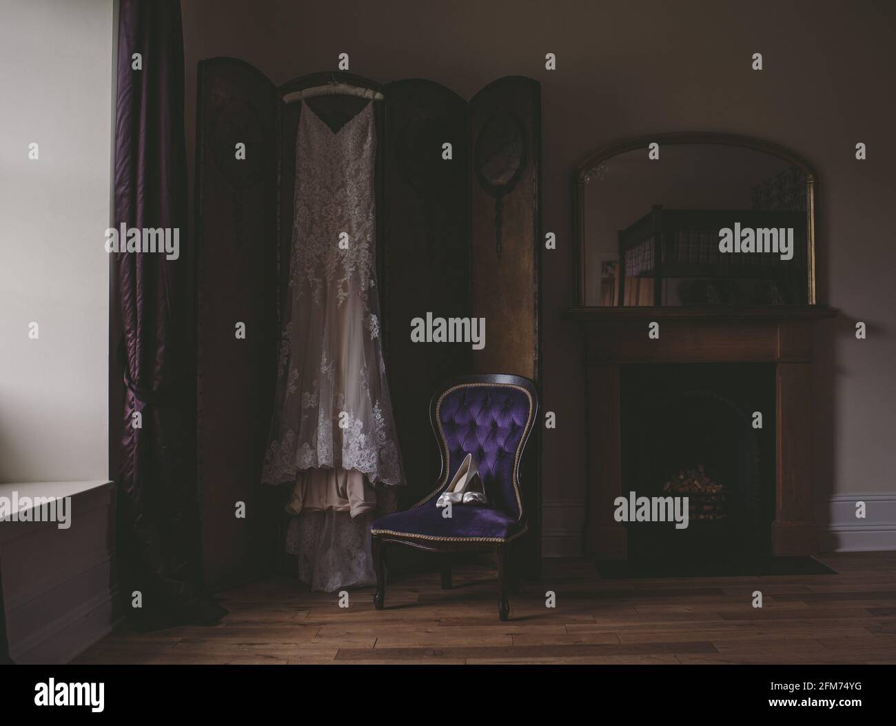 Wedding dress and shoes on display in a darkened room Stock Photo - Alamy
