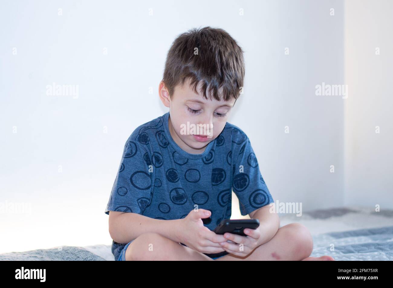 Child boy Playing with a smartphone with white background Stock Photo ...