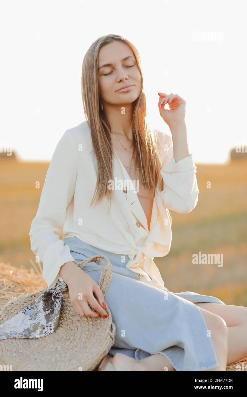 Beautiful portrait of a young woman during the sunset with warm yellow ...