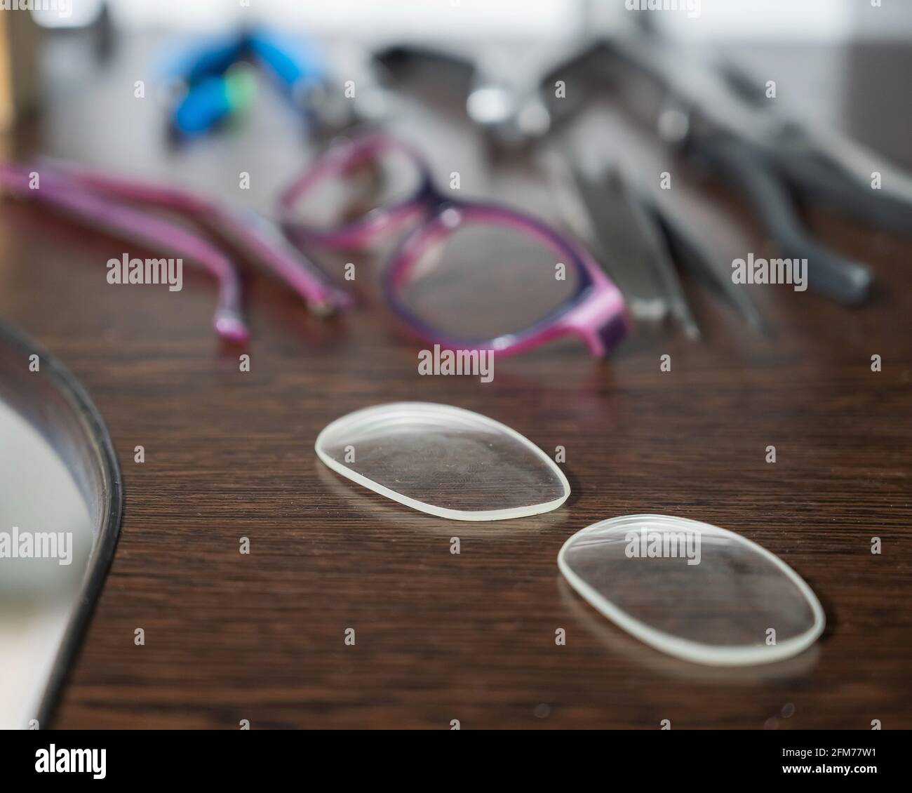 Optical technician work table. Close-up of lens frames and screwdrivers ...