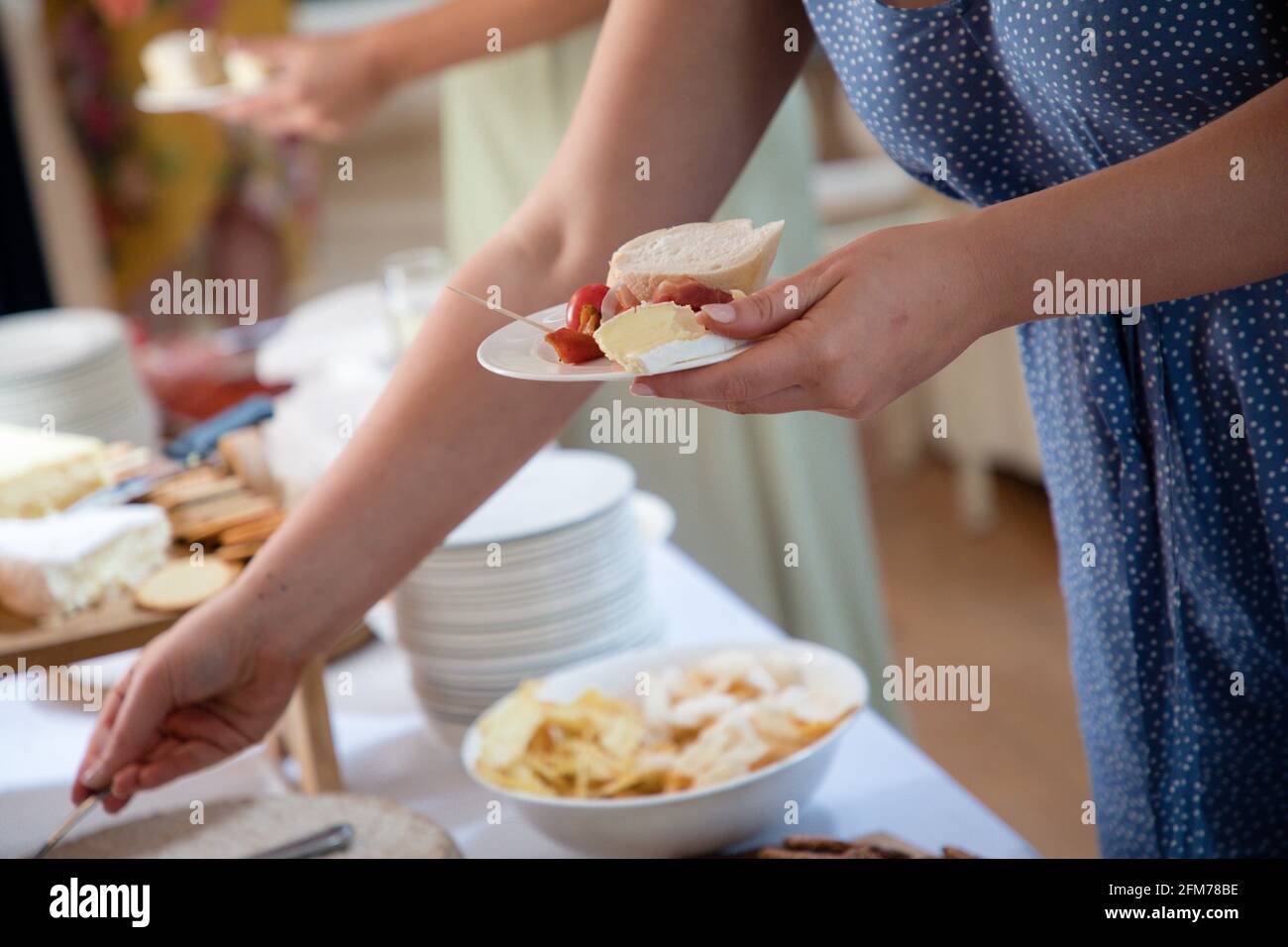 Womans hands and arms only choosing food and bread at a buffet or party ...