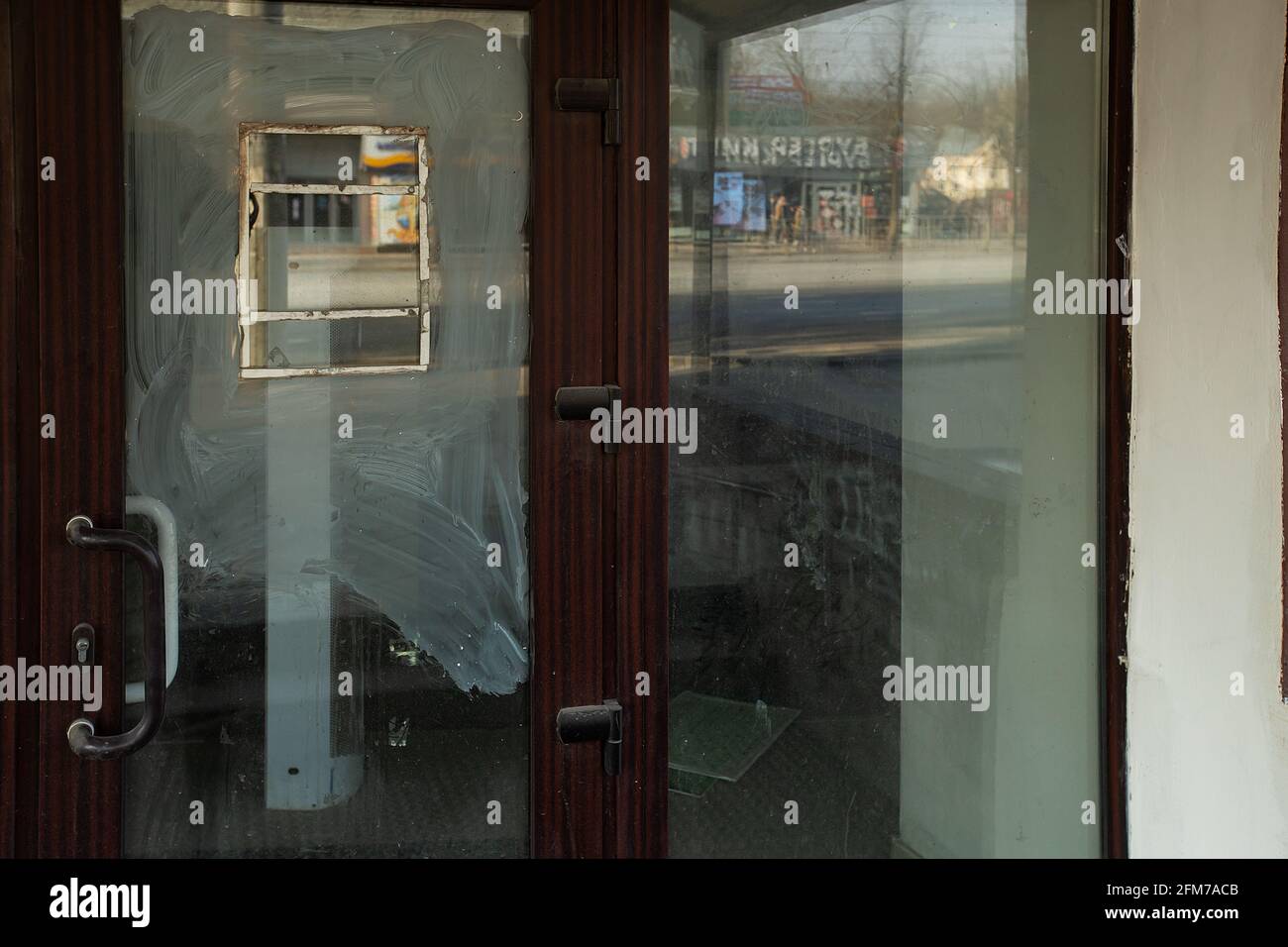 in the reflection of a glass window, a bakery clerk is mopping the ...