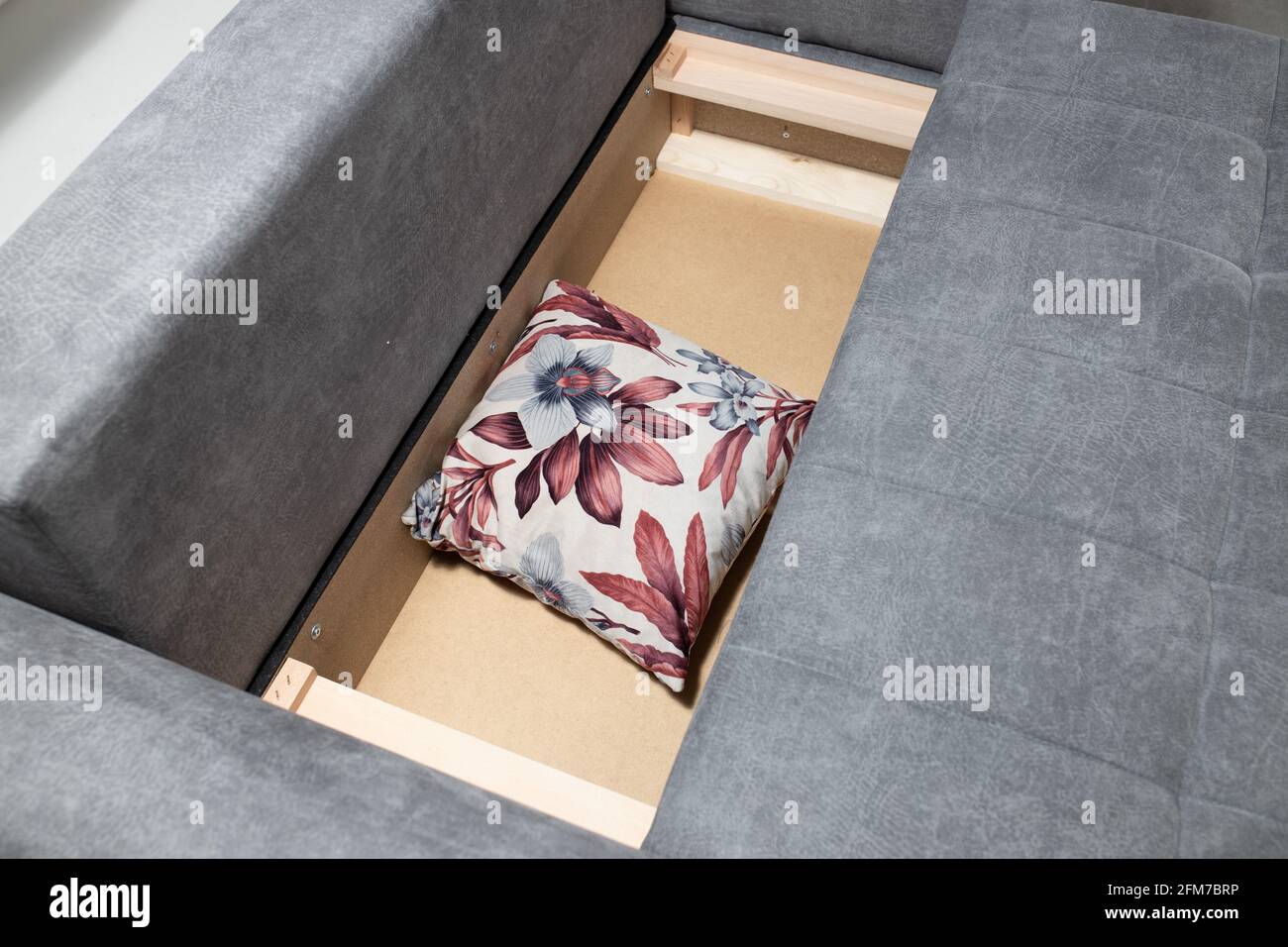 Grey drape couch that turns into a bed Stock Photo - Alamy