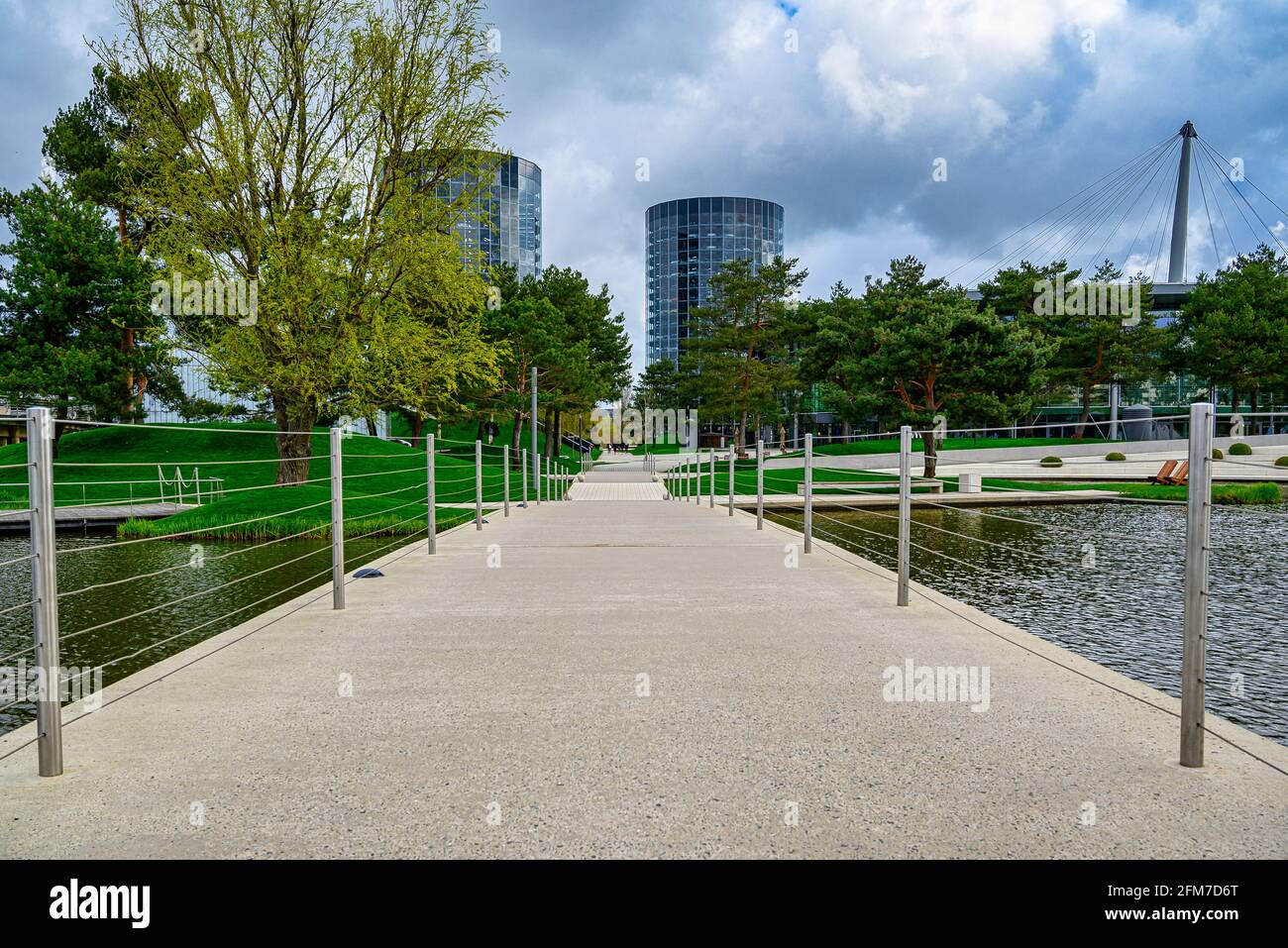 Beautiful footbridge over a calm lake in the green Autostadt park in ...
