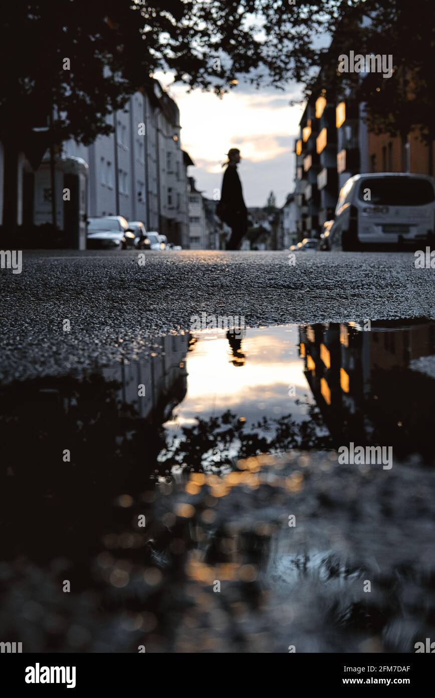 Low angle shot of reflection in a puddle on the street after the rain ...