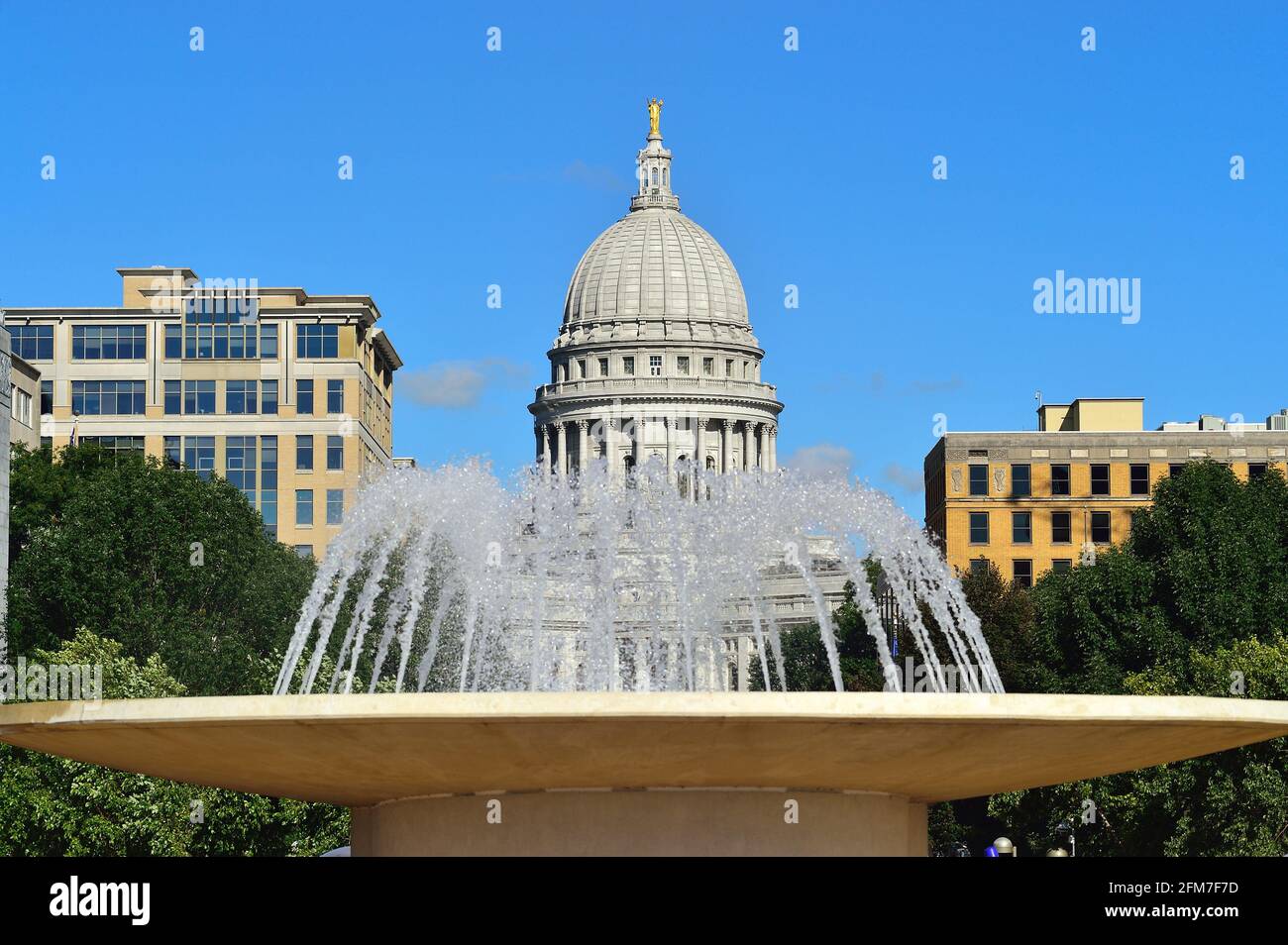 Madison, Wisconsin, USA. The State Capitol Building beyond a flowing ...