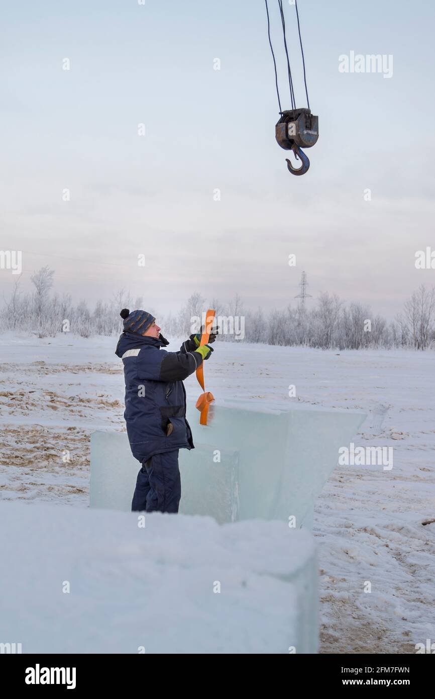 The slinger installer puts a tape rag rope on the hook Stock Photo - Alamy