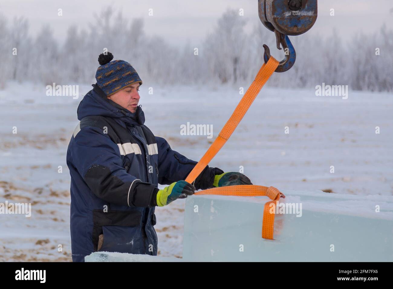 The slinger installer puts a tape rag rope on the hook Stock Photo - Alamy