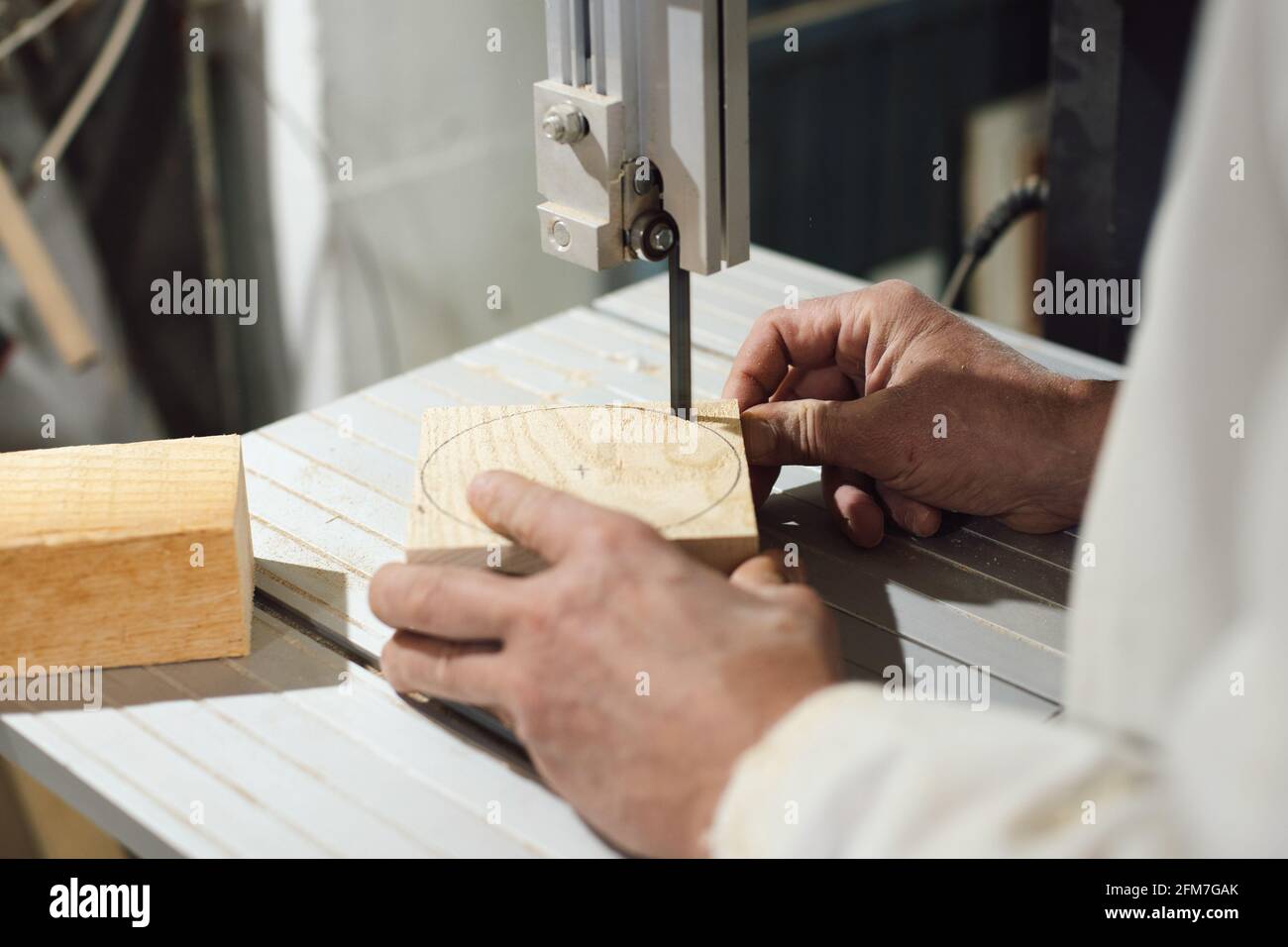 Woodworker cutting out a round marked space from a piece of wood with ...