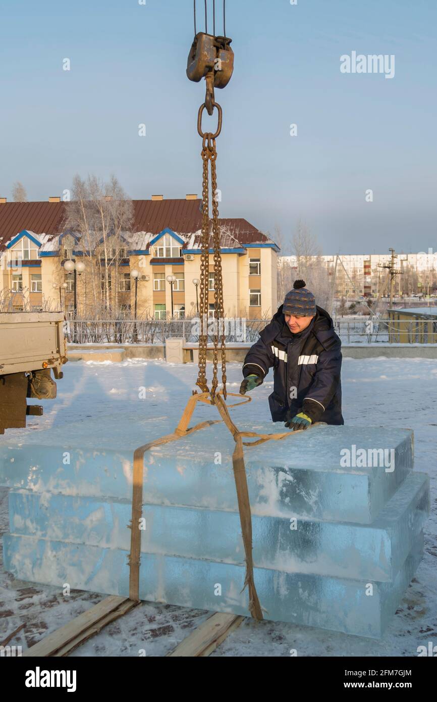 Slinger assembler in a blue jacket unloading ice panels using a truck ...