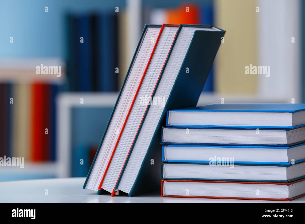 Stack of books on table in library Stock Photo - Alamy