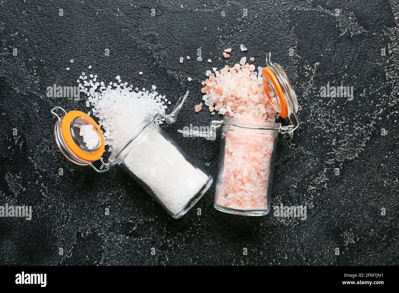 Jars with different salt on dark background Stock Photo - Alamy