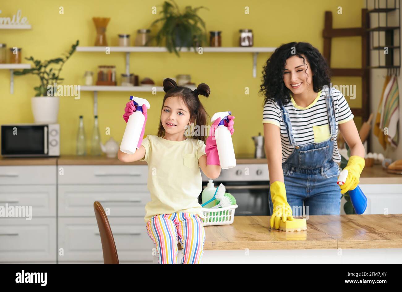 Mother and daughter cleaning table in kitchen Stock Photo - Alamy