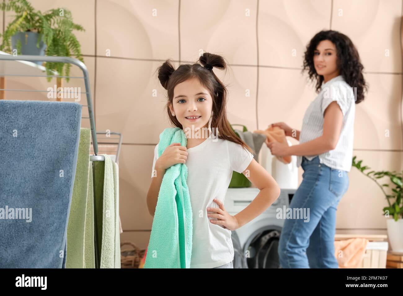 Mother and daughter doing laundry at home Stock Photo - Alamy