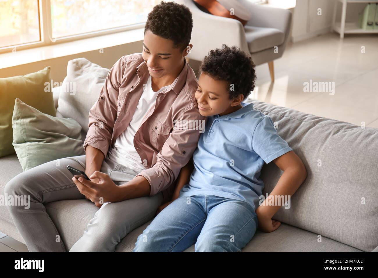 African-American boys using mobile phone in room Stock Photo - Alamy