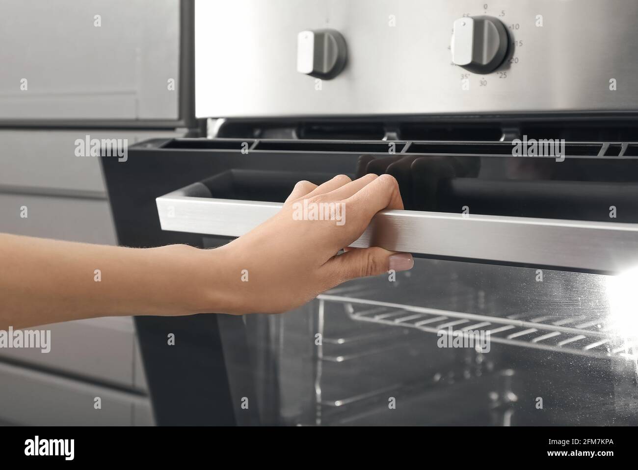 Woman opening oven in kitchen Stock Photo - Alamy