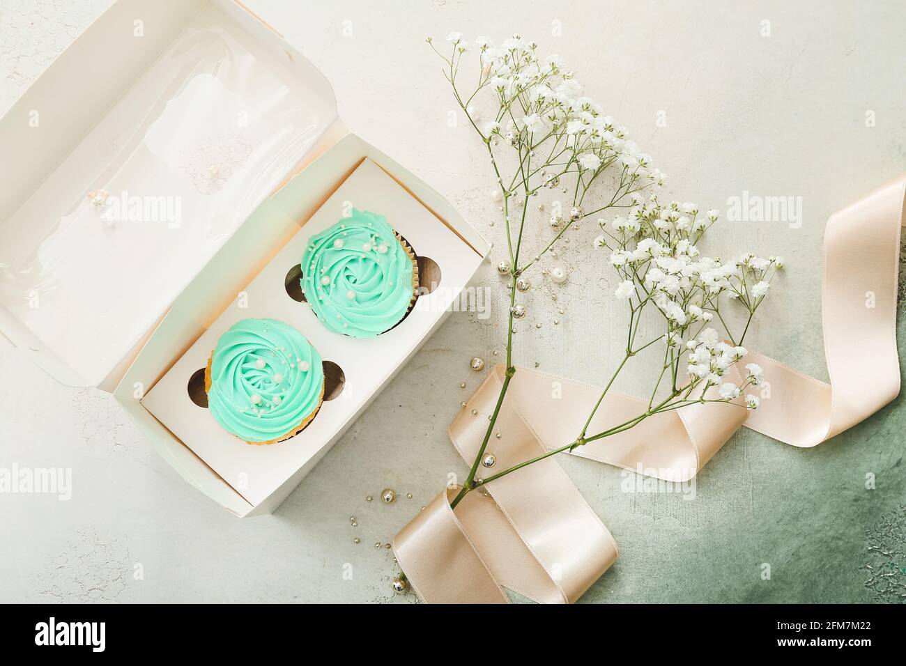 Composition with tasty cupcakes and flowers on color background Stock ...
