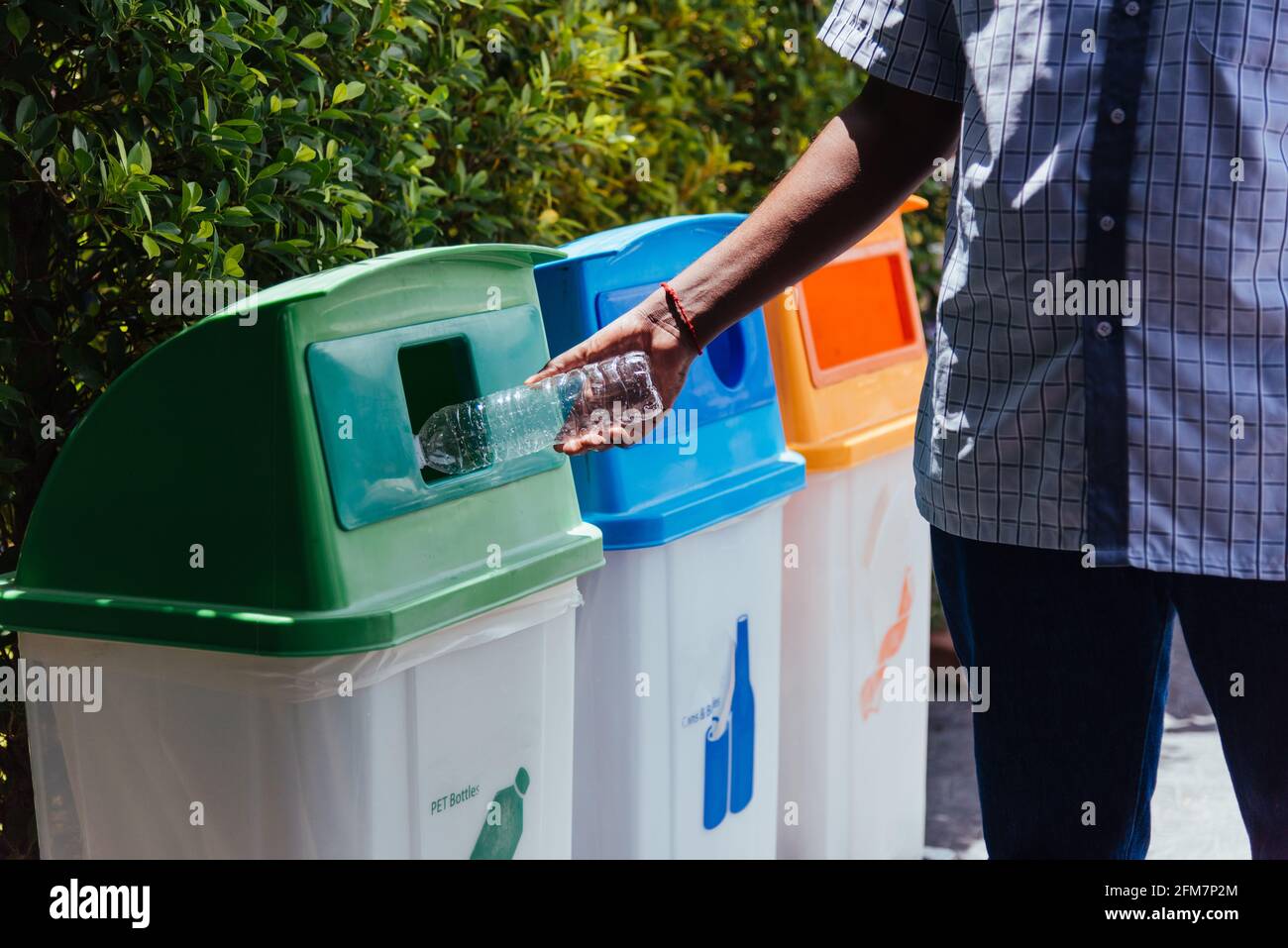 Selective focus close up the man black hand throwing an empty plastic water bottle in the ...