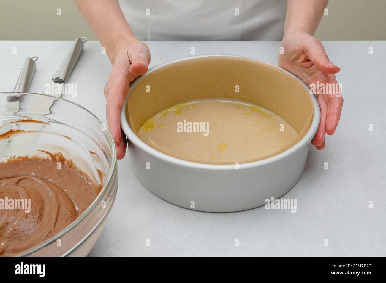 Cake pan lined with parchment paper close up on kitchen table ...