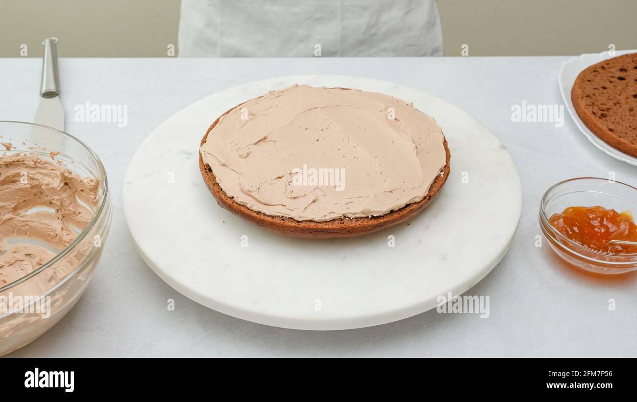 Assembling the chocolate cake. Placing chocolate cake frosting on first ...