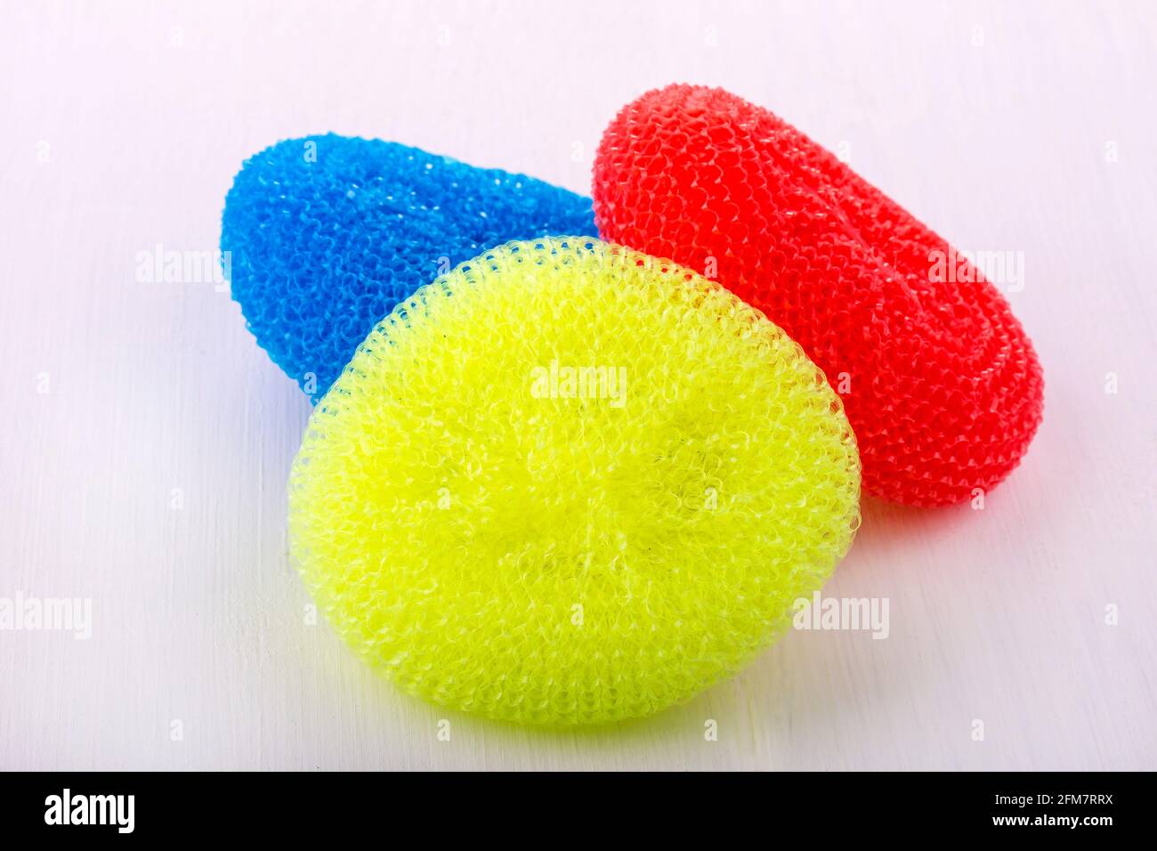 round sponges for washing dishes with different colors on a white ...